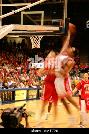 A slow shutter speed shot of a basketball player dribbling down court ...