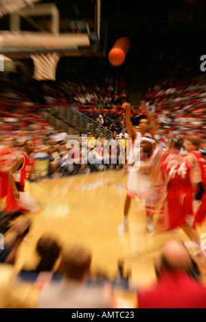 A slow shutter speed shot of a basketball player making a shot in this ...