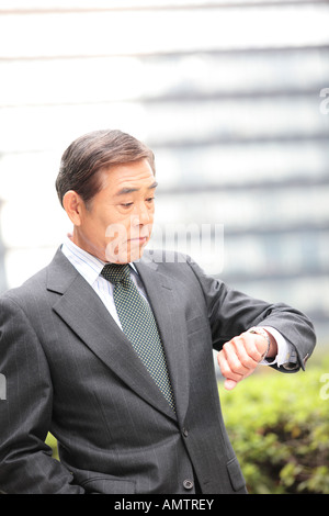Japanese office worker watching his wristwatch Stock Photo - Alamy