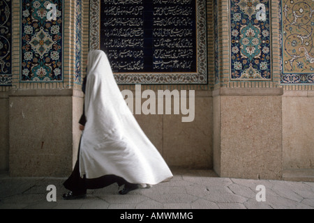 An Iranian woman in white chador (Islamic dressing code) stands on a ...