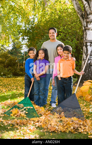 Father and daughter raking leaves Stock Photo - Alamy