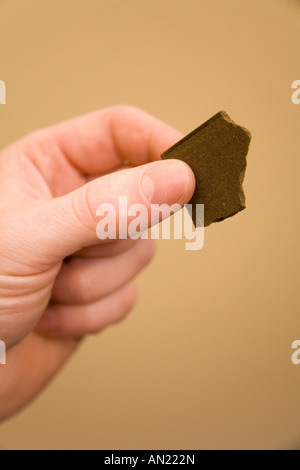 Hashish (cannabis resin) being held in a mans fingers Stock Photo - Alamy