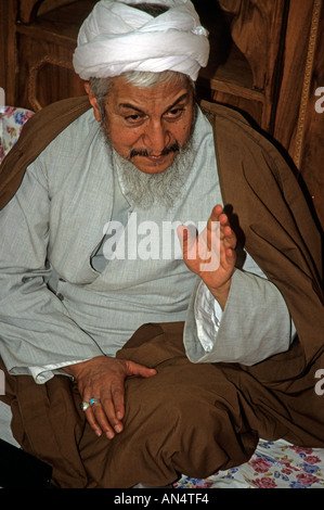 Iranian man in traditional attire walks in a narrow street in the old ...