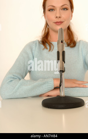 Young cute woman with retro microphone against bright glitter ...