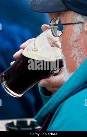Man drinking a pint of Guinness stout beer on a Stag weekend in Stock ...