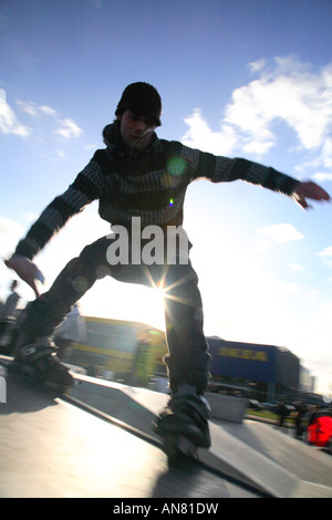 Inline skater doing trick in outdoor skatepark. In-line roller blader ...