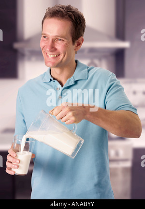 MAN IN KITCHEN POURING MILK Stock Photo - Alamy