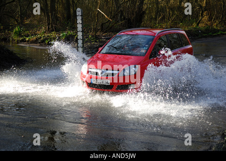 Vehicle driving through a stream. A car splashing water when driven ...
