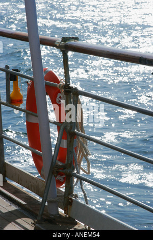 A life ring or lifebuoy attached to railings of a ship, ready to be ...