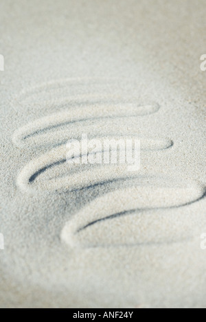 Squiggle pattern track traced into sand Stock Photo - Alamy