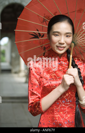 young pretty chinese woman standing against wall Stock Photo - Alamy