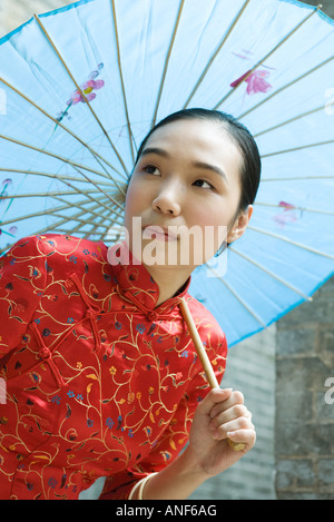 Woman is dressed in red Chinese Japanese folk clothing. Flying fabric ...