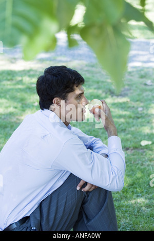 30s hispanic man eating grass and smiling in park buenos aires ...