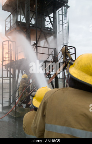 Planned teamwork fire fighting practice Stock Photo - Alamy