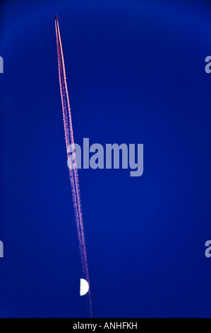 a jet plane flying past the moon at sunset Stock Photo - Alamy