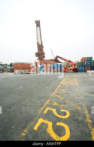 Container stacks and crane in shipyard at dusk for cargo Goods and ...