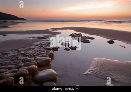 post sunset view of beach at Dunraven Bay with sky reflected in a rock ...