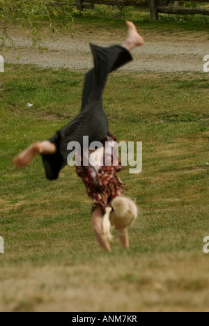 Child girl doing somersault outdoors. Little kid tumbling outside in ...