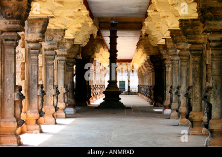 A long passage lined on both sides by stone pillars with sculptures and ...