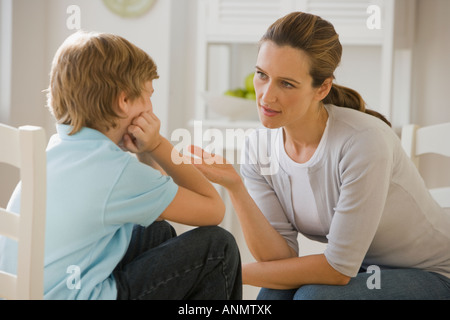 Mother and son having a serious discussion in a cozy living room at ...