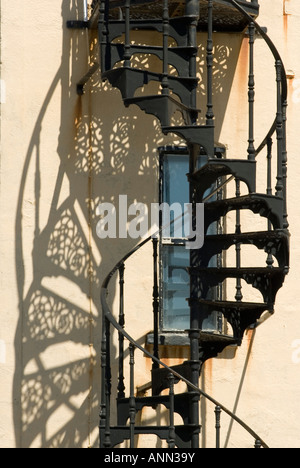 External metal spiral staircase on an orange building facade next to ...
