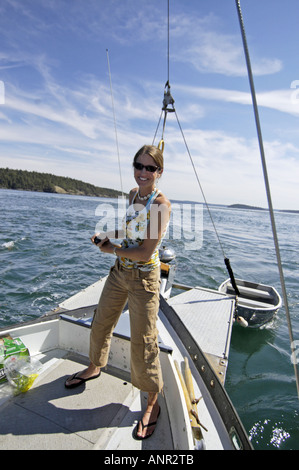Woman steering a sail boat while sailing in the San Juan Islands off ...