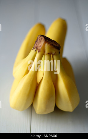 Banana bunch on a light wooden background Stock Photo - Alamy