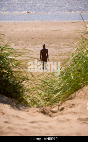 An iconic Another Place, cast Iron Man statue stands amidst the sand ...