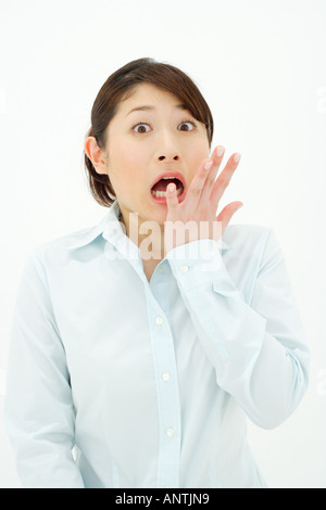 Surprised asian woman gasping, looking amazed at camera, impressed face ...
