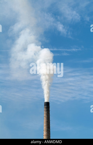 Industrial chimney with smoke by a blue sky Stock Photo - Alamy