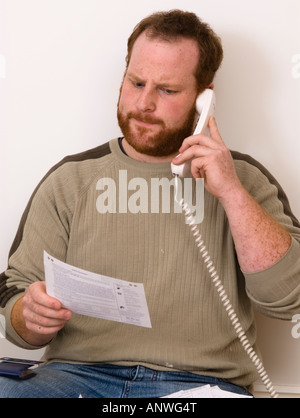 man on phone questioning items on bank statement Stock Photo - Alamy