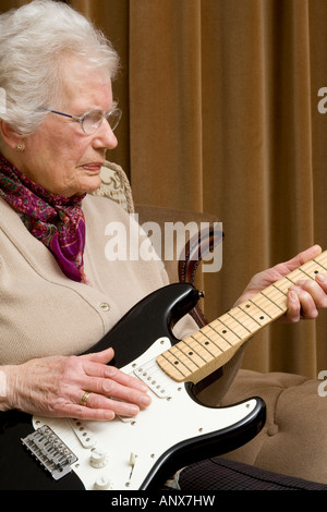 Elderly lady playing a guitar Stock Photo - Alamy