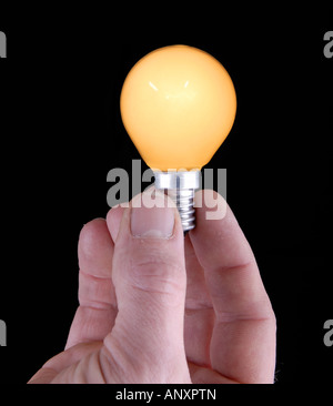 fingers holding a low energy light bulb Stock Photo - Alamy