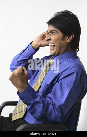 happy man talking on mobile phone and laughing while sitting on couch ...