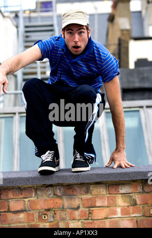 Young adult man over brick wall holding banner very happy pointing with ...