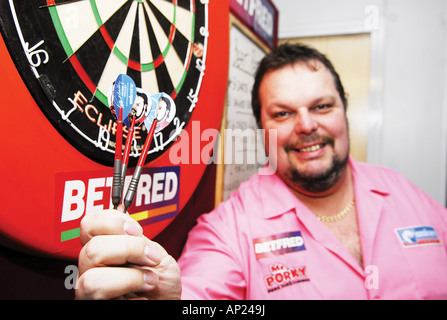 Professional dart player Peter Manley at the dart board holding darts ...