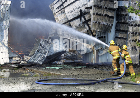 TWO FIREFIGHTERS SPRAYING FIRE WITH WATER FROM HOSE Stock Photo - Alamy
