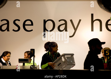 Shop assistant at checkout in ASDA store, Tottenham, north London Stock ...