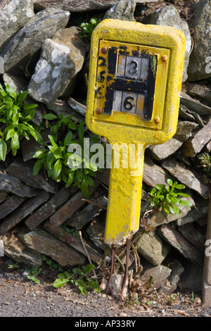 Yellow concrete water main marker Stock Photo - Alamy