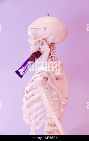 A human skeleton eating a bar of chocolate Stock Photo - Alamy