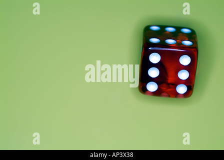 red loaded die on red background Stock Photo - Alamy