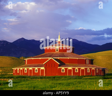 TWIN BRIDGES MONTANA USA Farm tractor moves round bales of hay west of ...