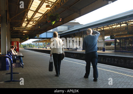 Passengers wait for a train at a platform in the central train station ...
