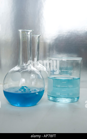 science research chemistry flasks and beakers with blue solution in ...