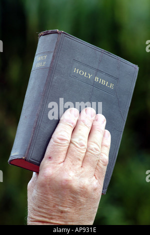 Raised hand holding the Holy Bible in front of Mount Fuji in Japan ...