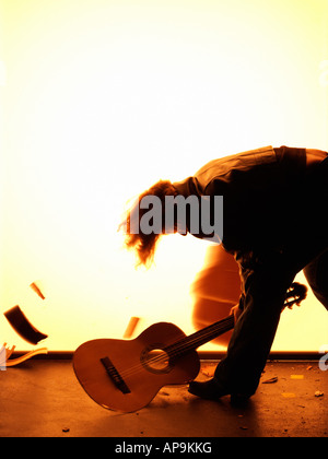 silhouette of a man smashing his guitar Stock Photo - Alamy