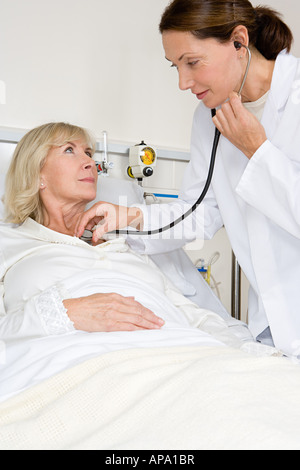 Doctor examining a female patient with a stethoscope Stock Photo ...