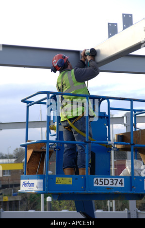 Steel worker bolting together steel beams for new building Stock Photo ...