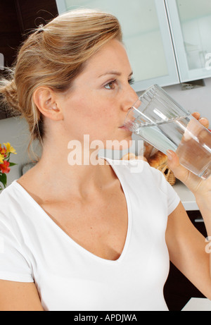 Woman drinking a glass of mineral water Stock Photo - Alamy