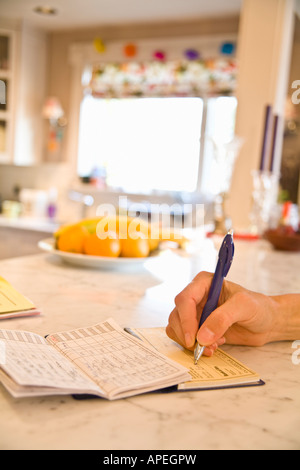 Close-up Of A Person's Hand Writing On Chequered Spiral Notepad With ...